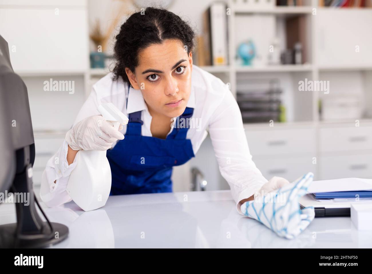 Female worker cleaning desk in office Stock Photo - Alamy