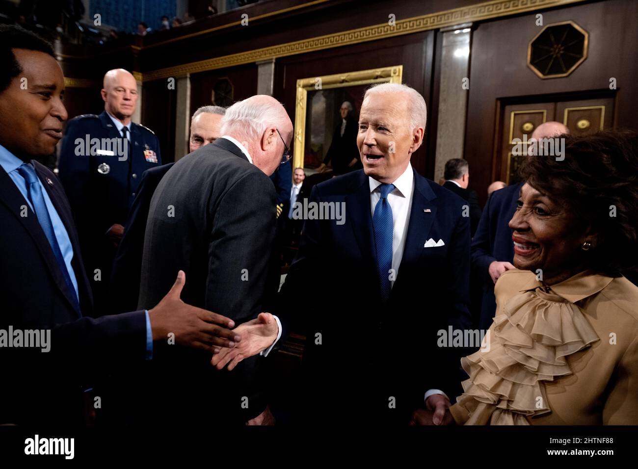 US President Joe Biden (C) shakes hands with Representative Joe Neguse ...