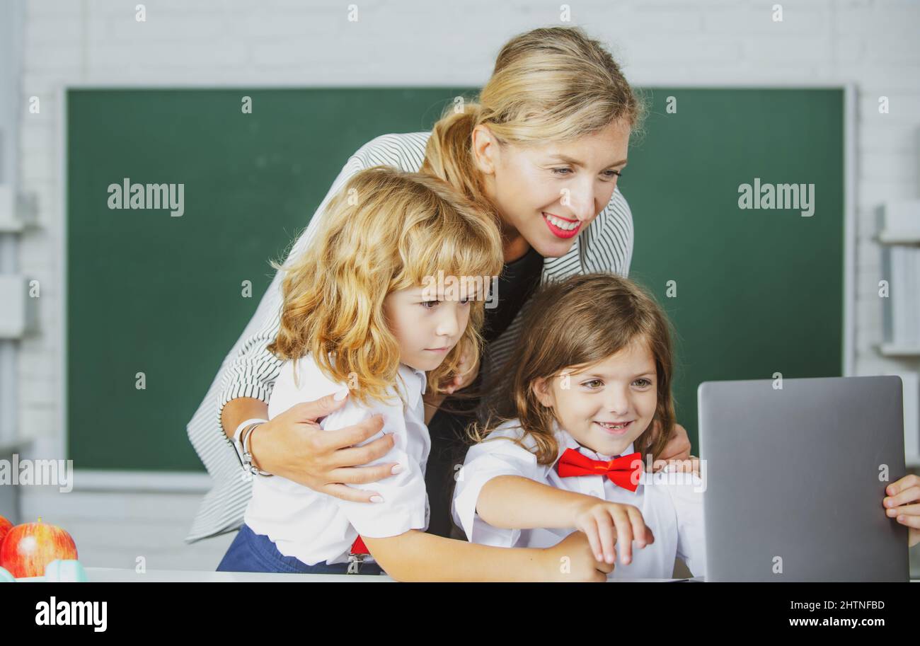 Teacher with Elementary School Pupils using Laptop at Desk Stock Photo ...