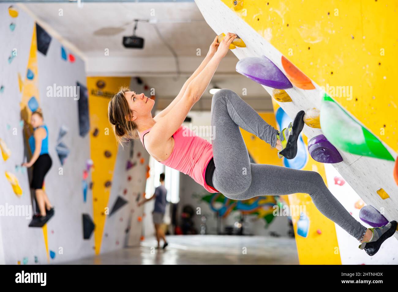 Woman climbing on rock-climbing wall Stock Photo - Alamy