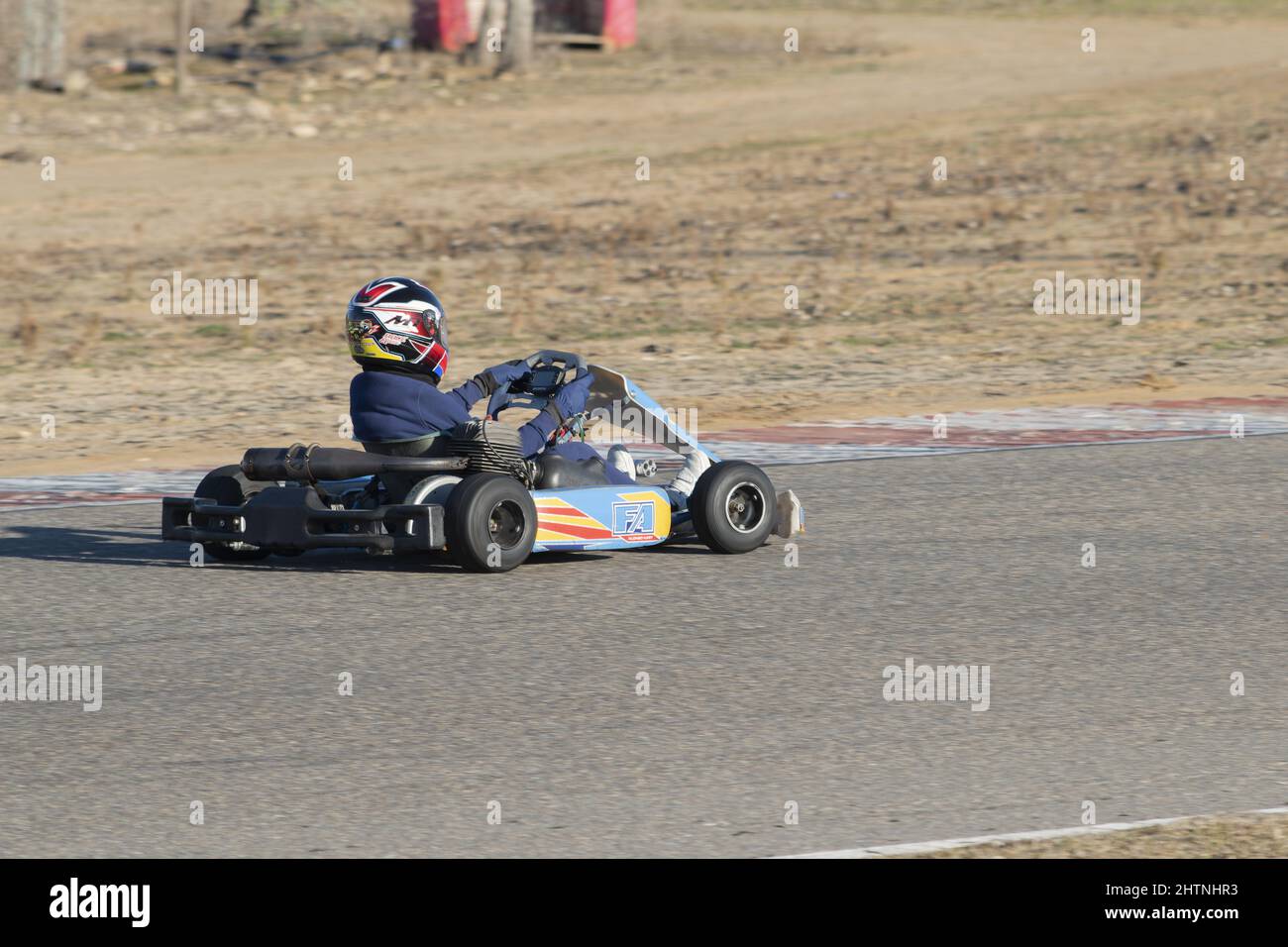 Child in helmet driving go-kart on karting circuit at daytime Stock ...