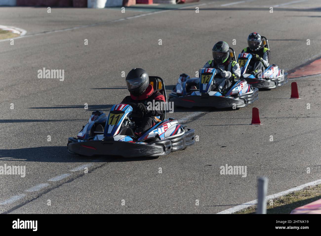 Karting track with men racing go-karts Stock Photo - Alamy