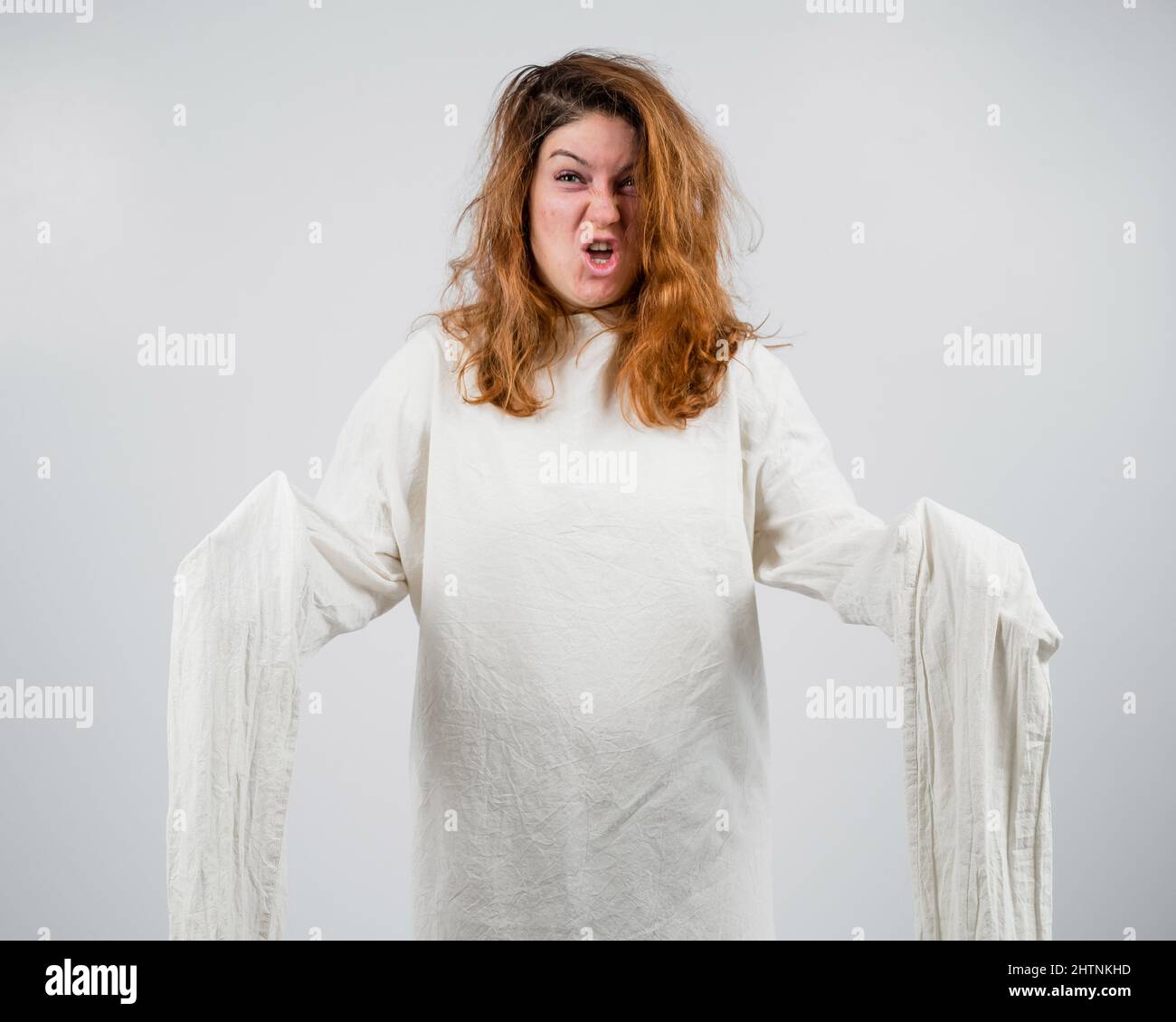 Close-up portrait of insane woman in straitjacket on white background ...