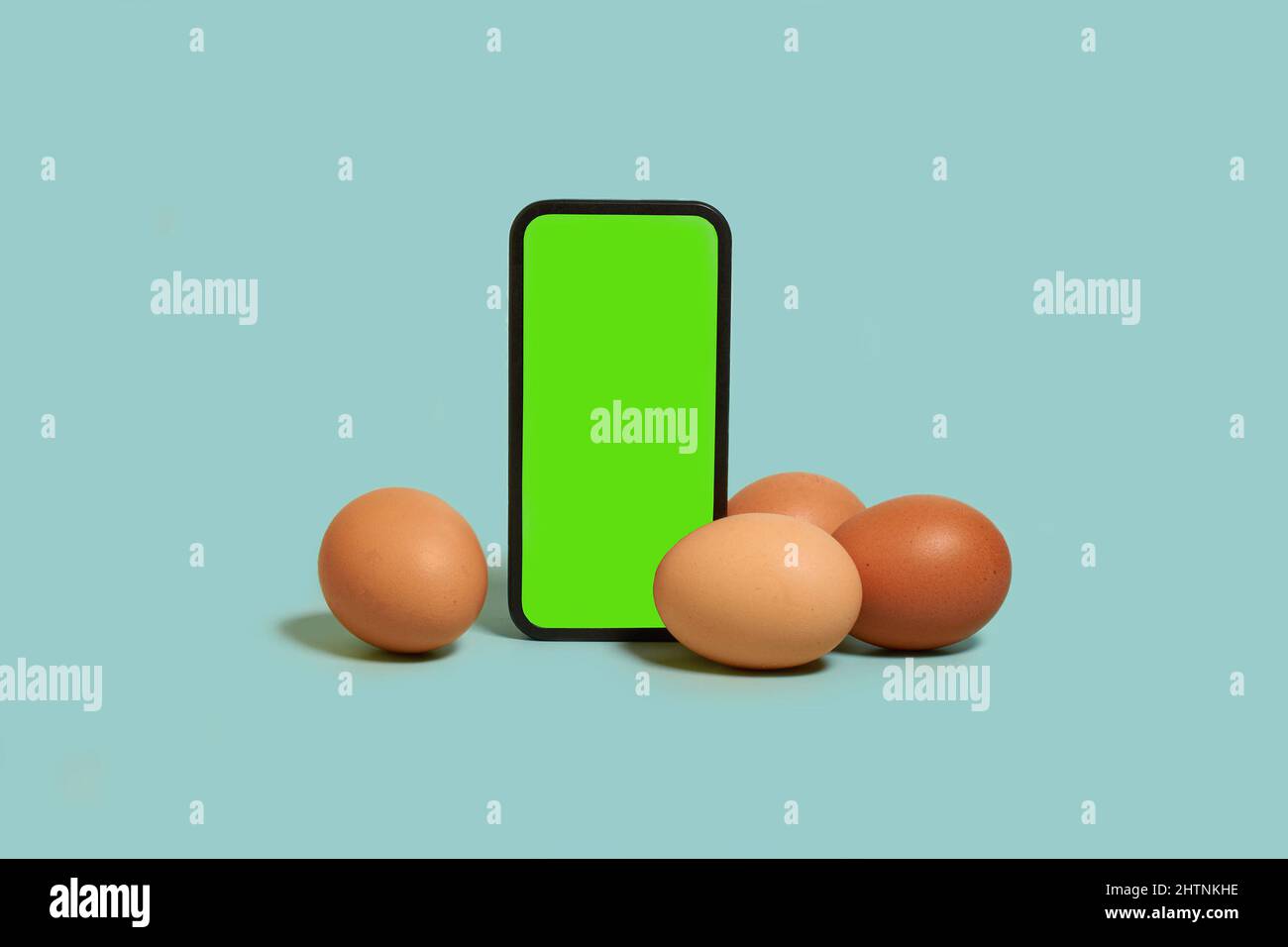 Online shopping. A smartphone with a green screen and chicken eggs ...