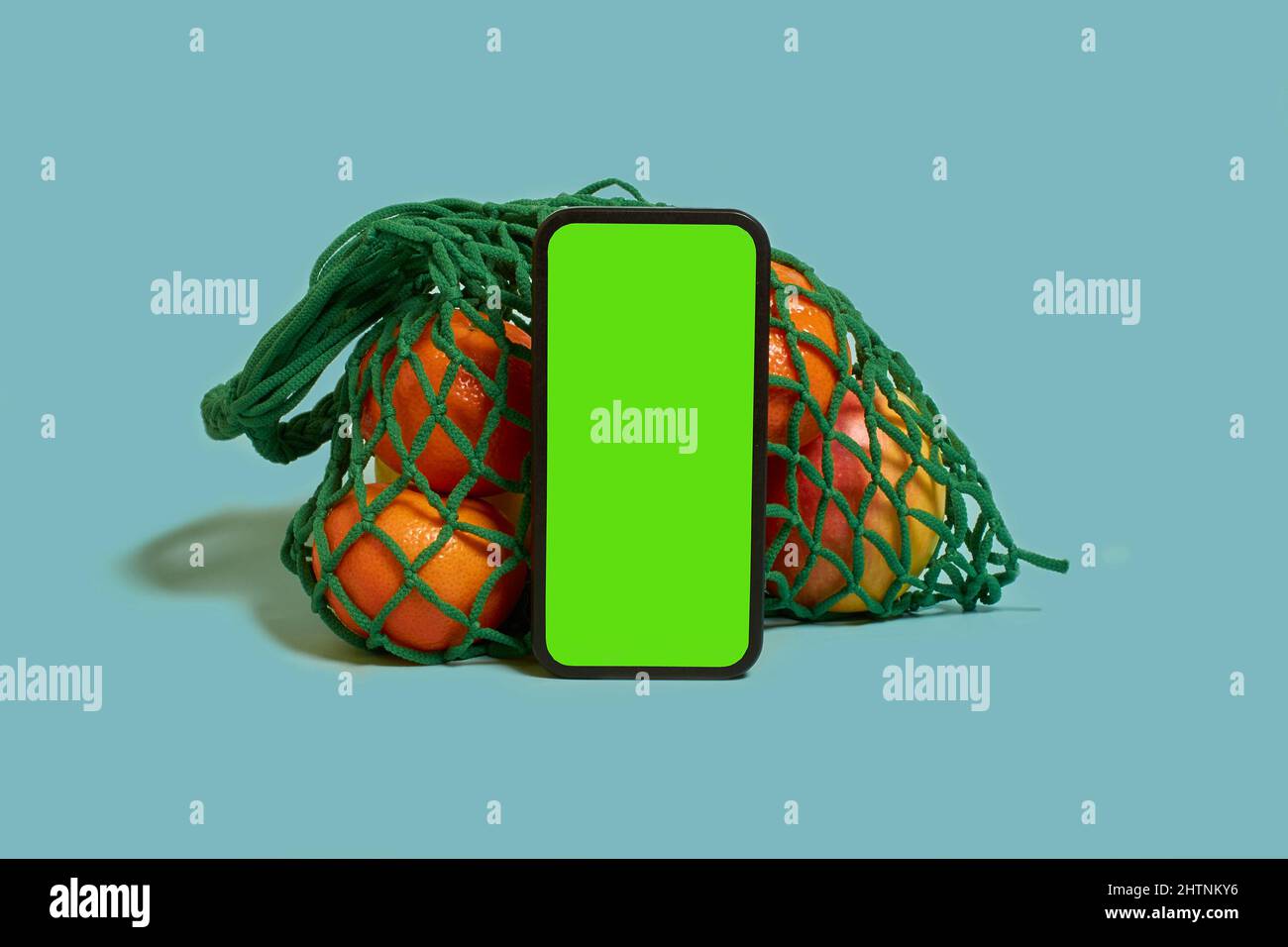 A smartphone with a green screen, fruits and citrus in a mesh bag Stock ...