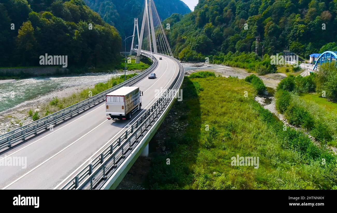Truck crosses beautiful bridge in summer. Scene. Top view of truck ...