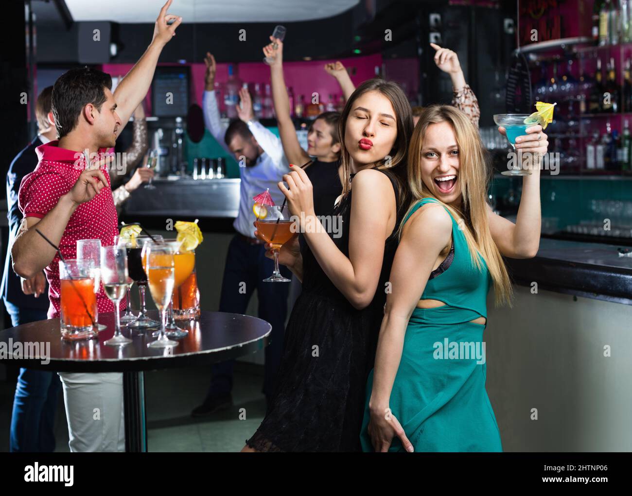 Portrait of smiling females and males having fun in the bar Stock Photo ...