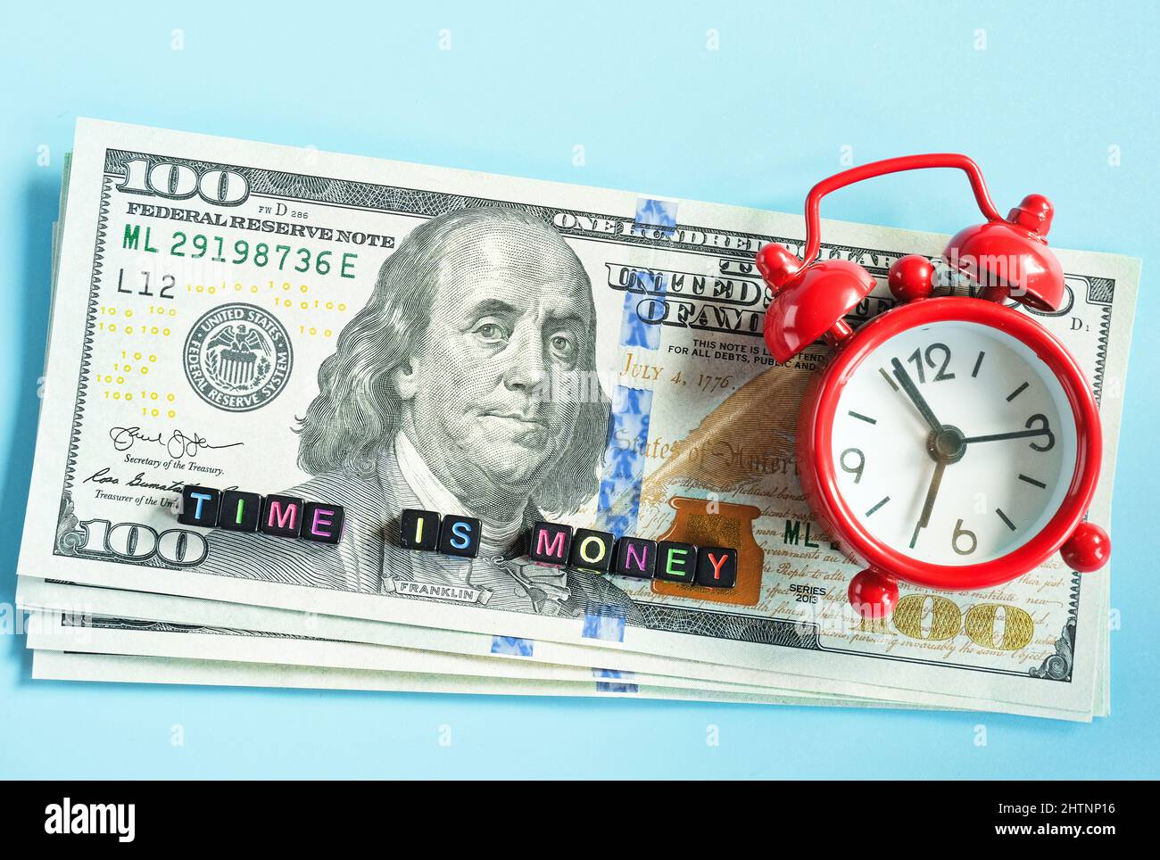 Time is money text and red alarm clock on background of American ...