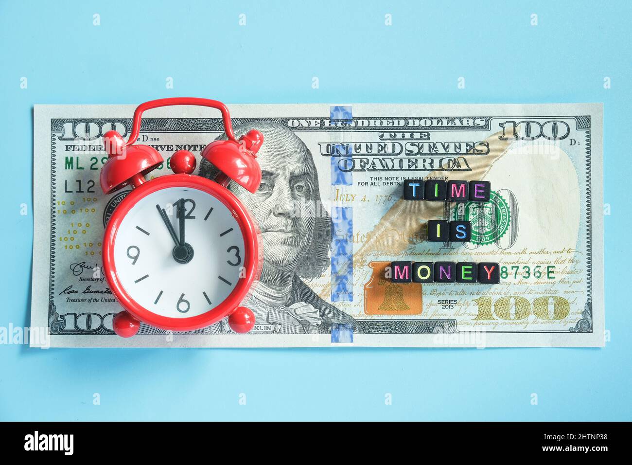 Time is money text and red alarm clock on background of American ...
