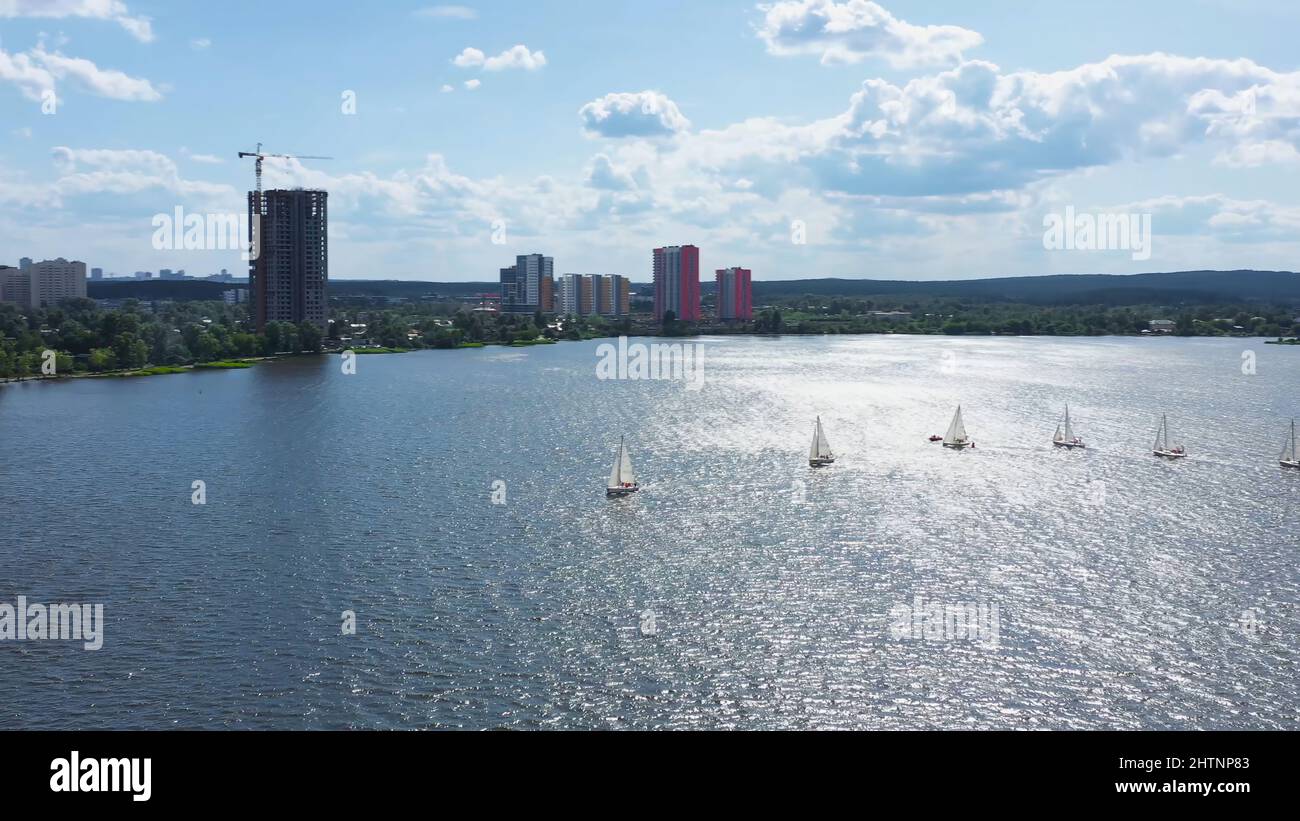 Sailing yachts on background of coast with high-rise buildings of city ...
