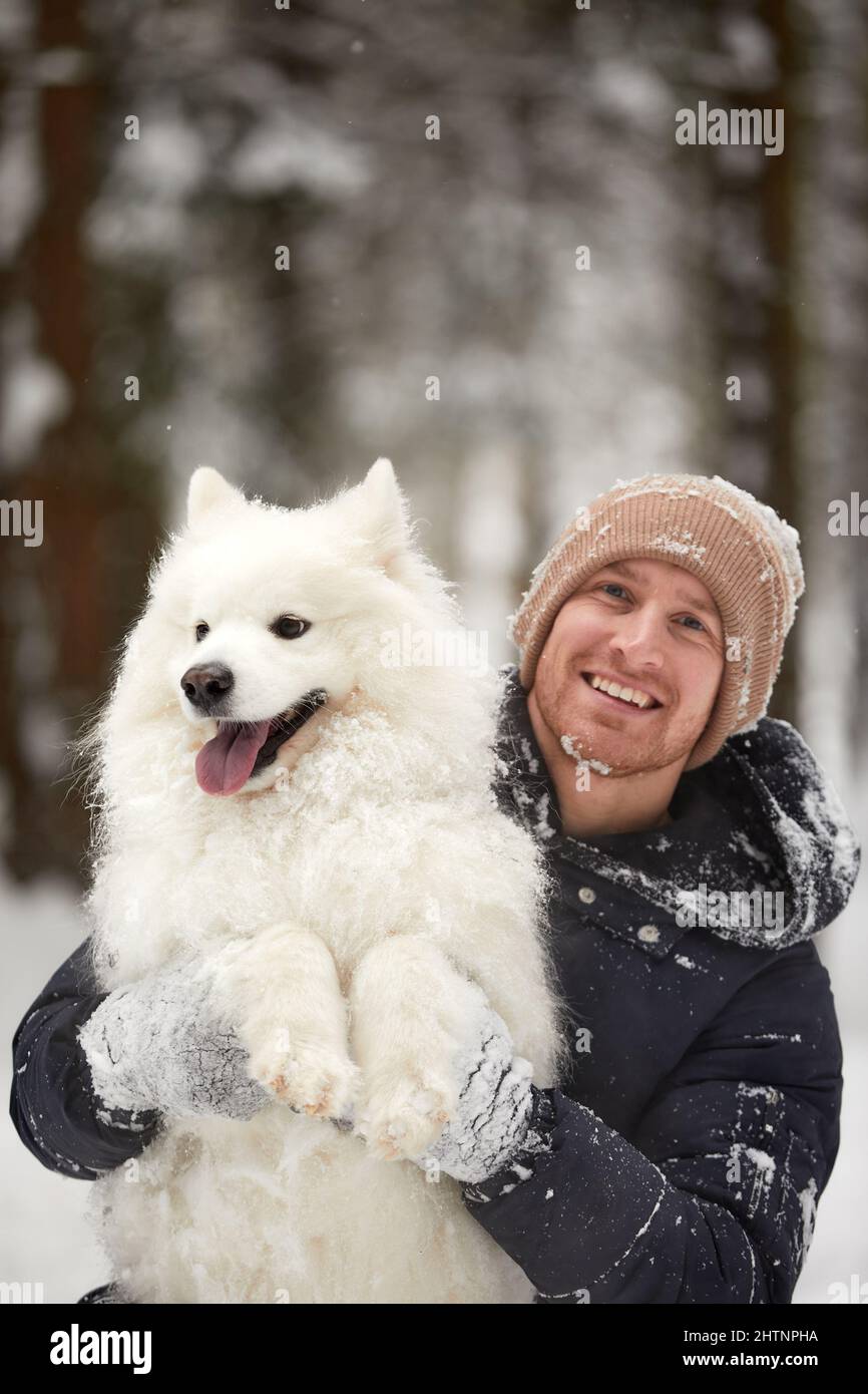 A human and a dog are best friends. Man and dog walk in snowy forest in ...
