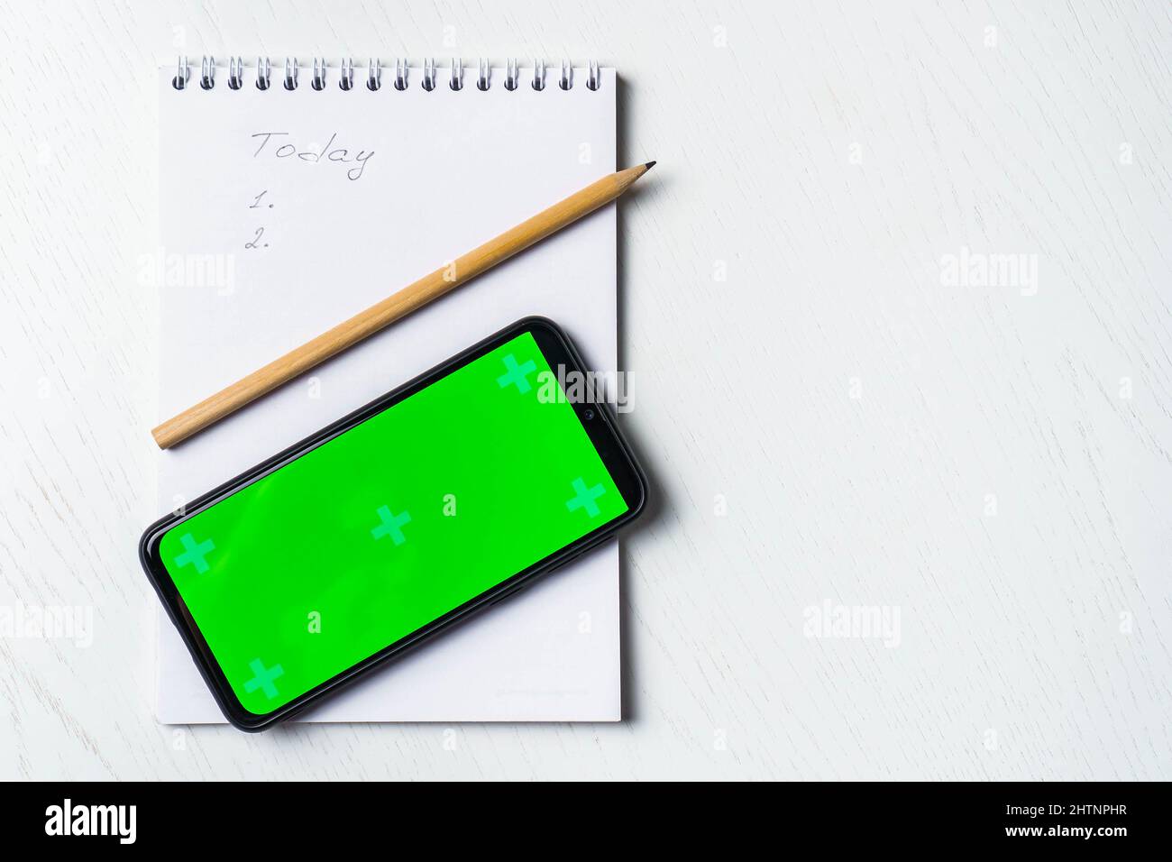 White notepad with inscription today, smartphone green screen mockup ...