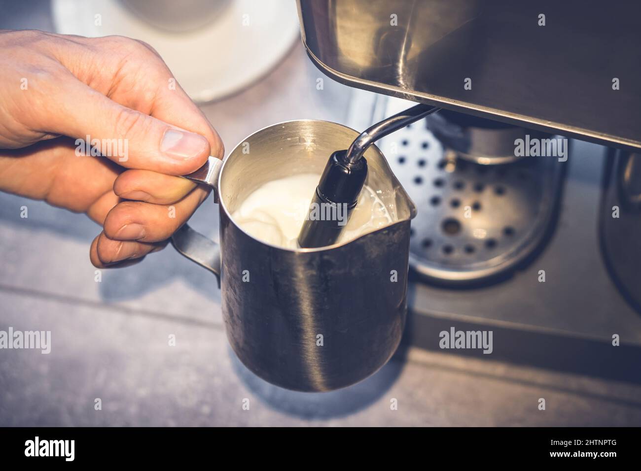 Cappuccino preparation. Barista beating milk in milk seller. Steamer ...