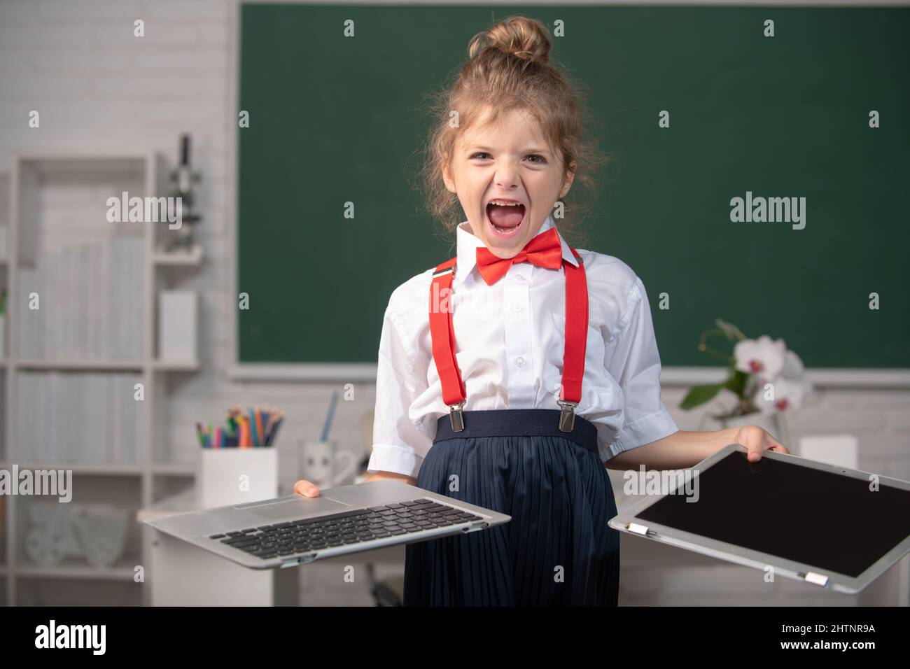 Angry girl in opposition distance education. School kid broken online ...