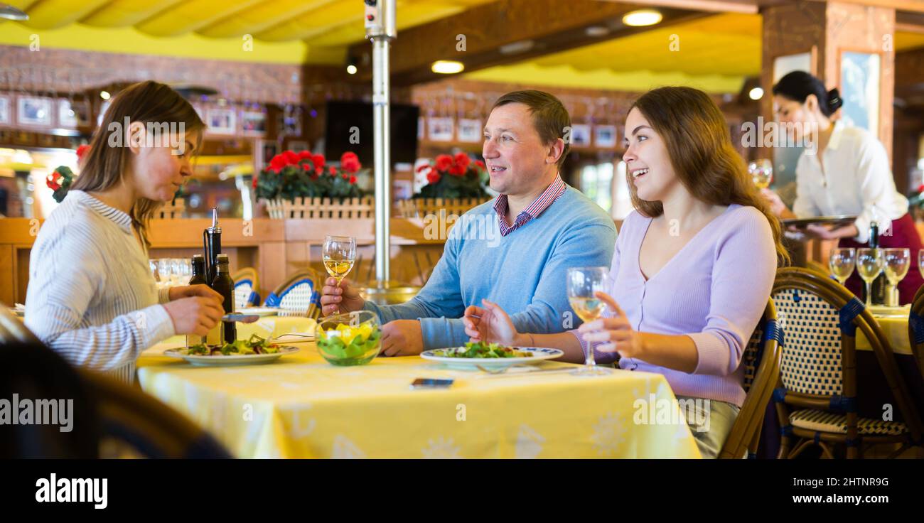 Happy friends meeting in restaurant during dinner Stock Photo - Alamy