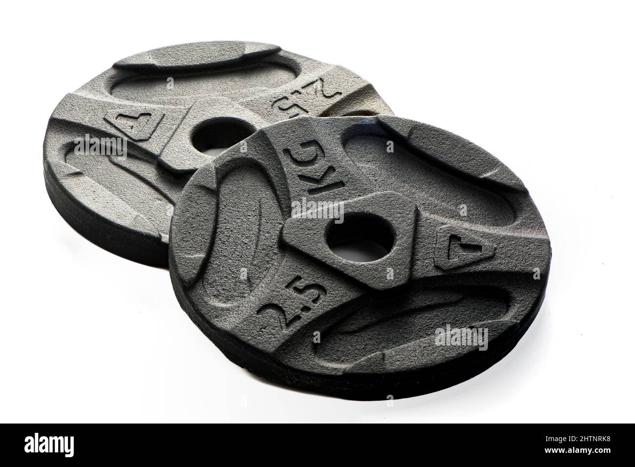 Two black metal pancakes of 2.5 kg each lie on a white isolated ...