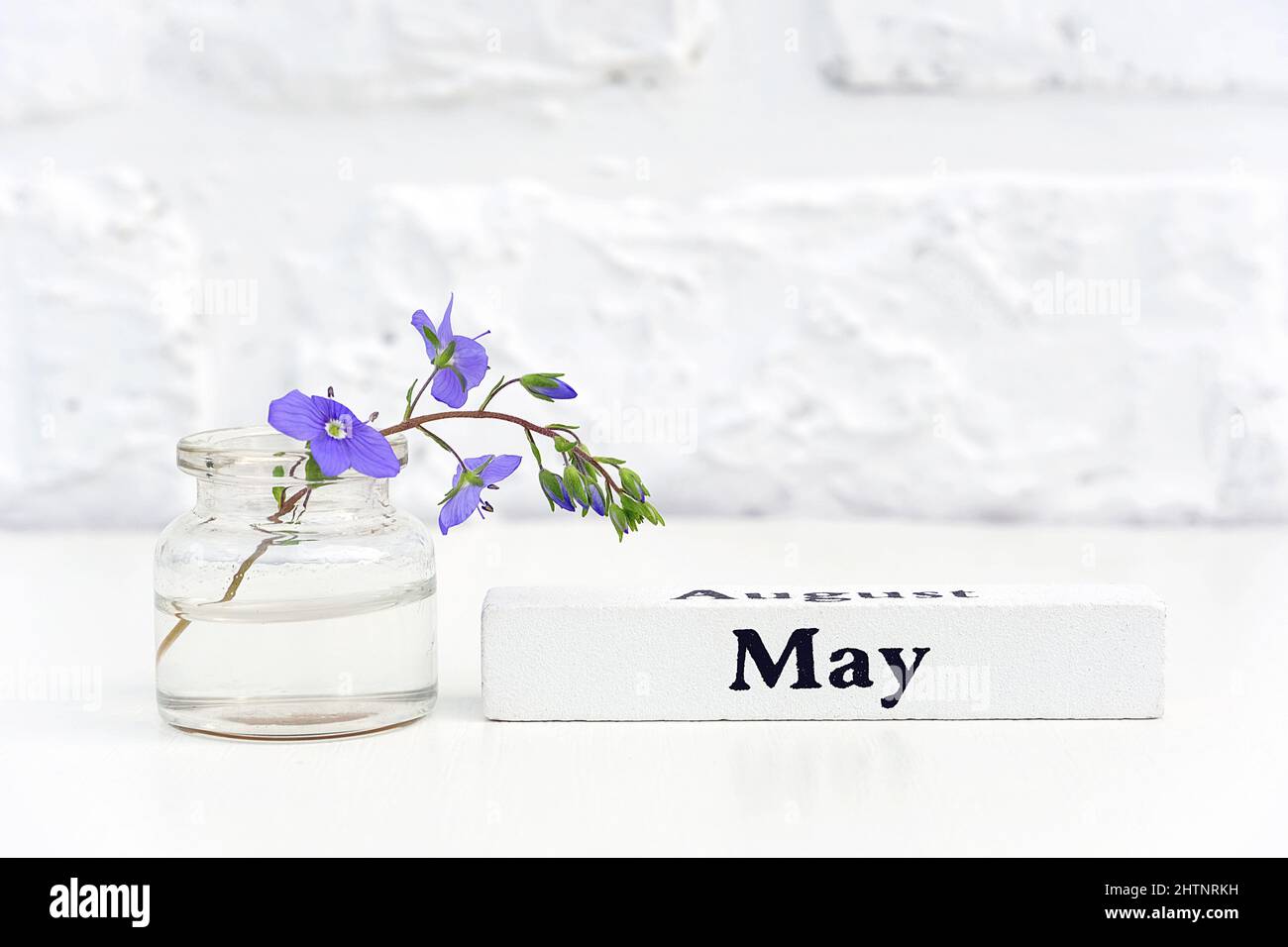 Wood calendar spring month May and blue flower in bottle vase on table ...