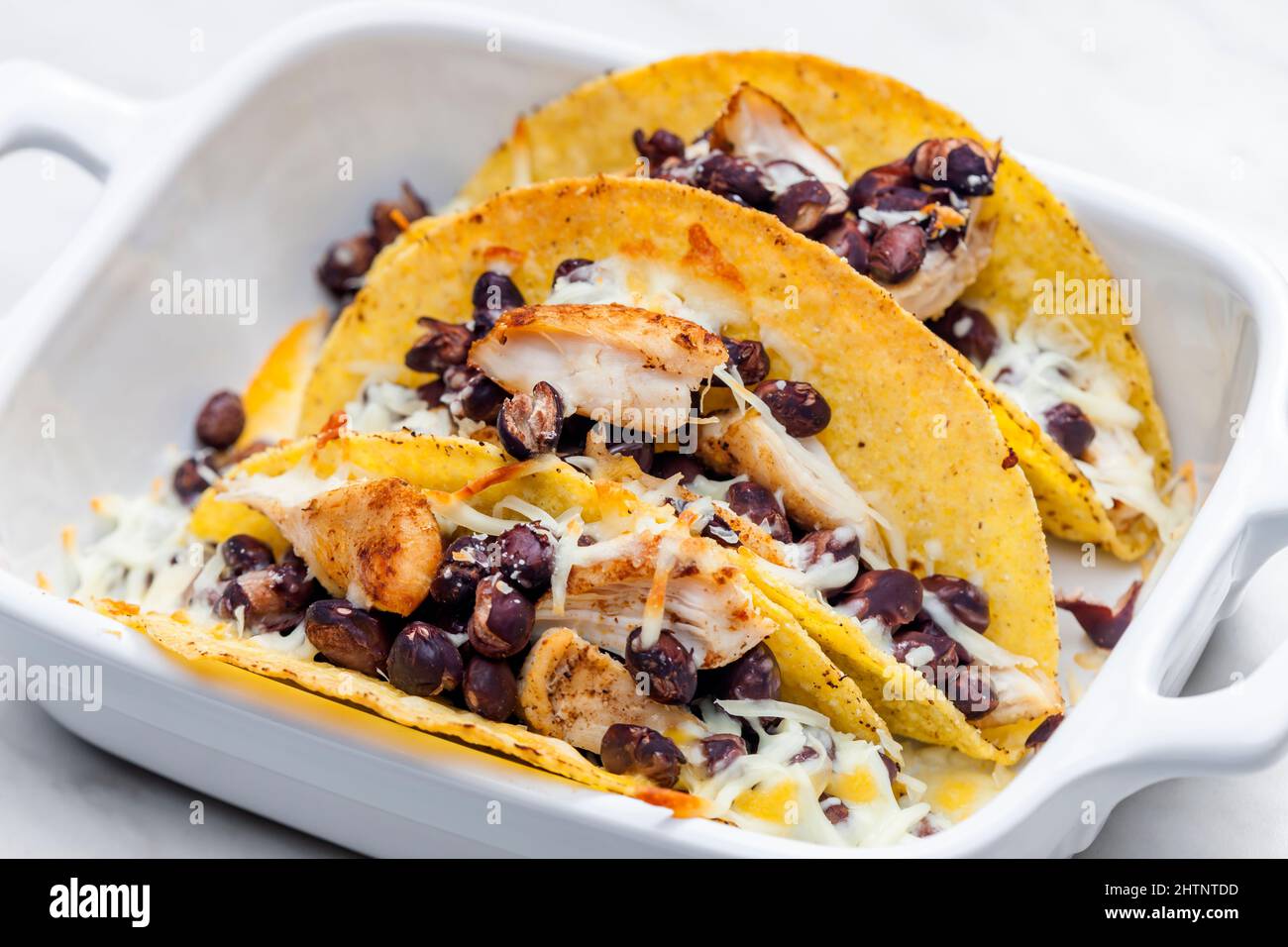 tacos filled with grilled chicken meat, red beans and grated cheese ...