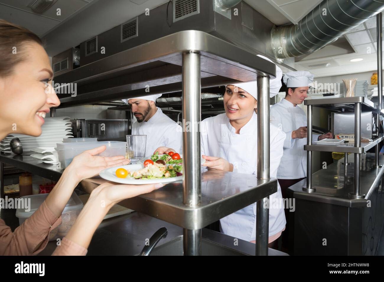 Staff of restaurant with head chef working Stock Photo - Alamy