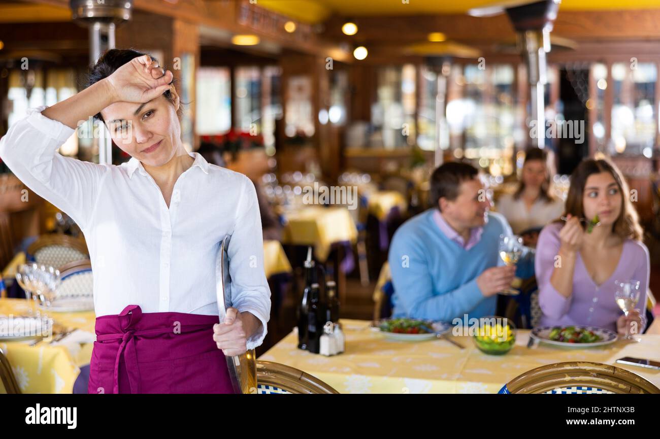 Portrait of tired waitress in restaurant Stock Photo - Alamy
