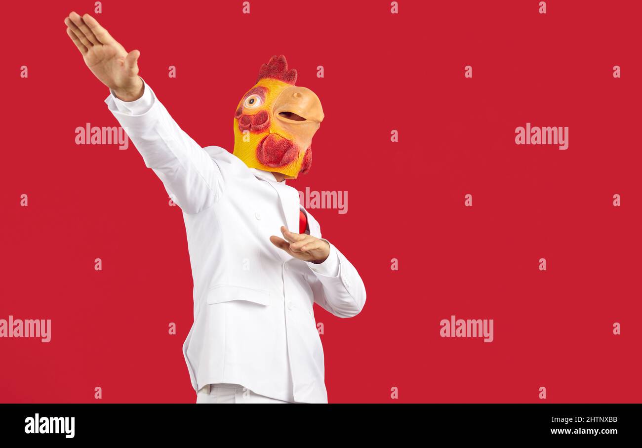 Funny crazy man in white formal suit dancing chicken mask on his head ...