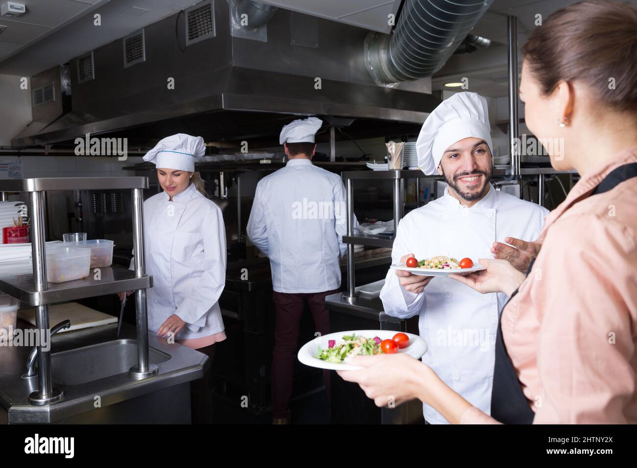 Head chef checking dishes in kitchen Stock Photo - Alamy