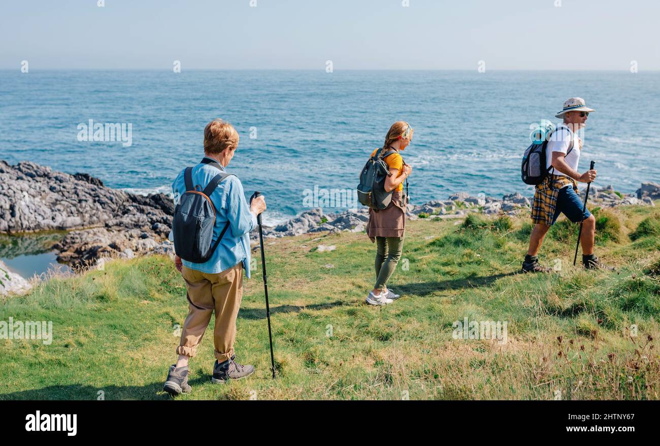 Adult family hiking along the coast Stock Photo - Alamy