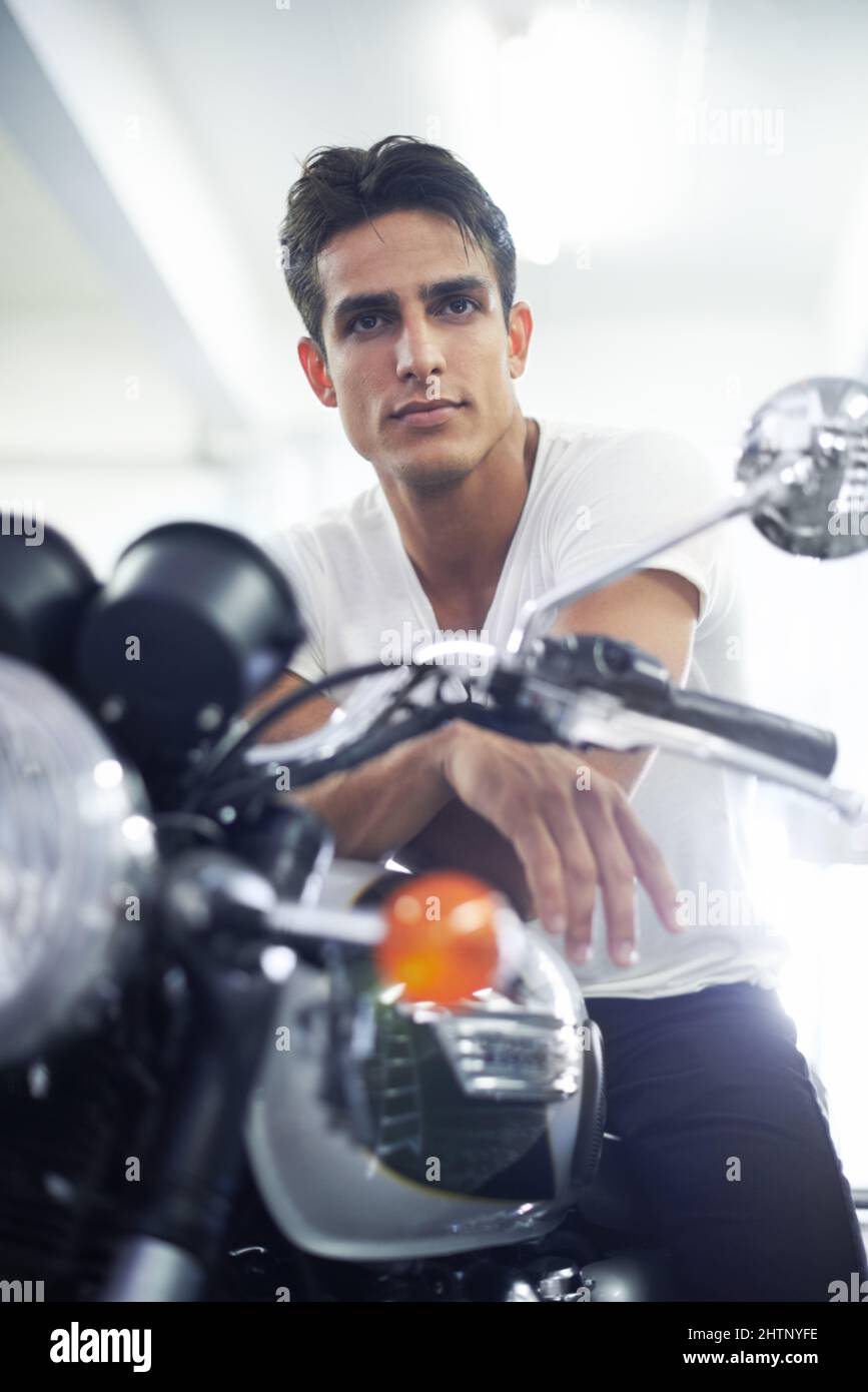 Looking great on his new bike. A handsome young man sitting on his ...