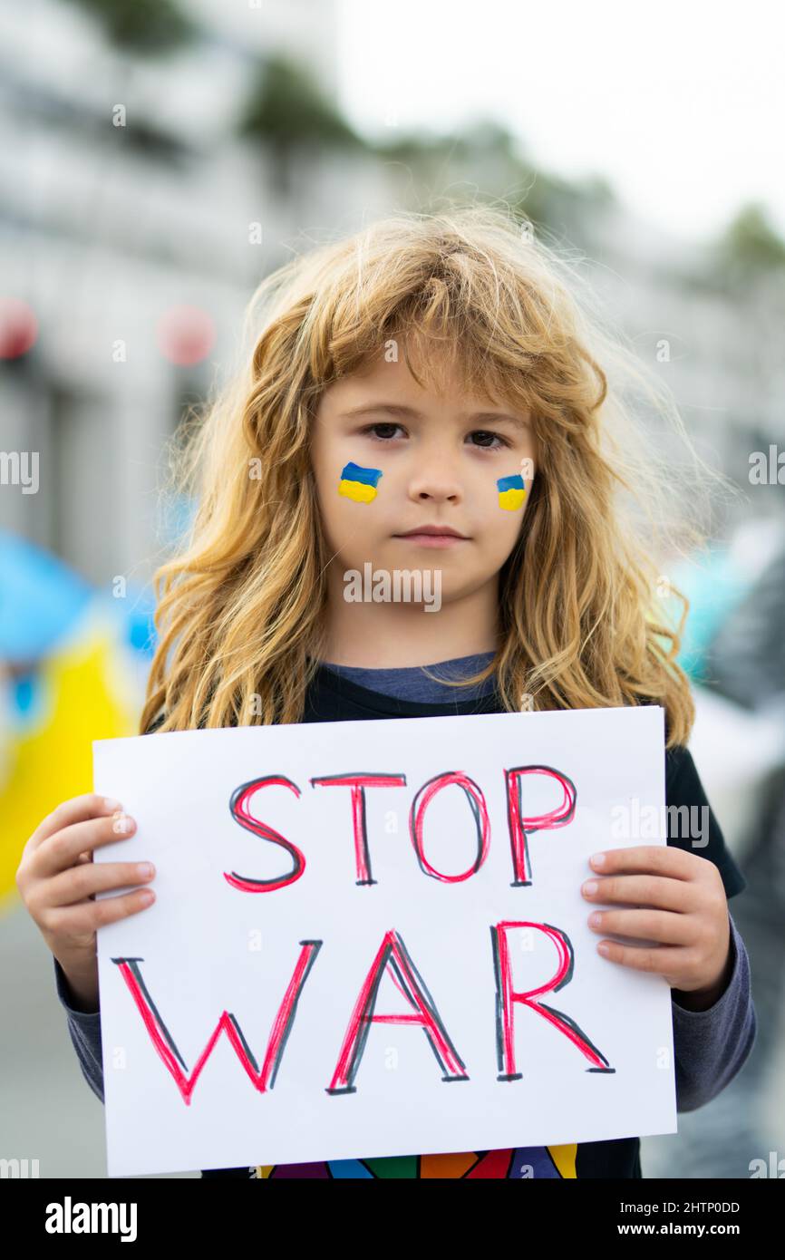Young child in a protest with ukrainian flag and poster Stop war. Kids ...