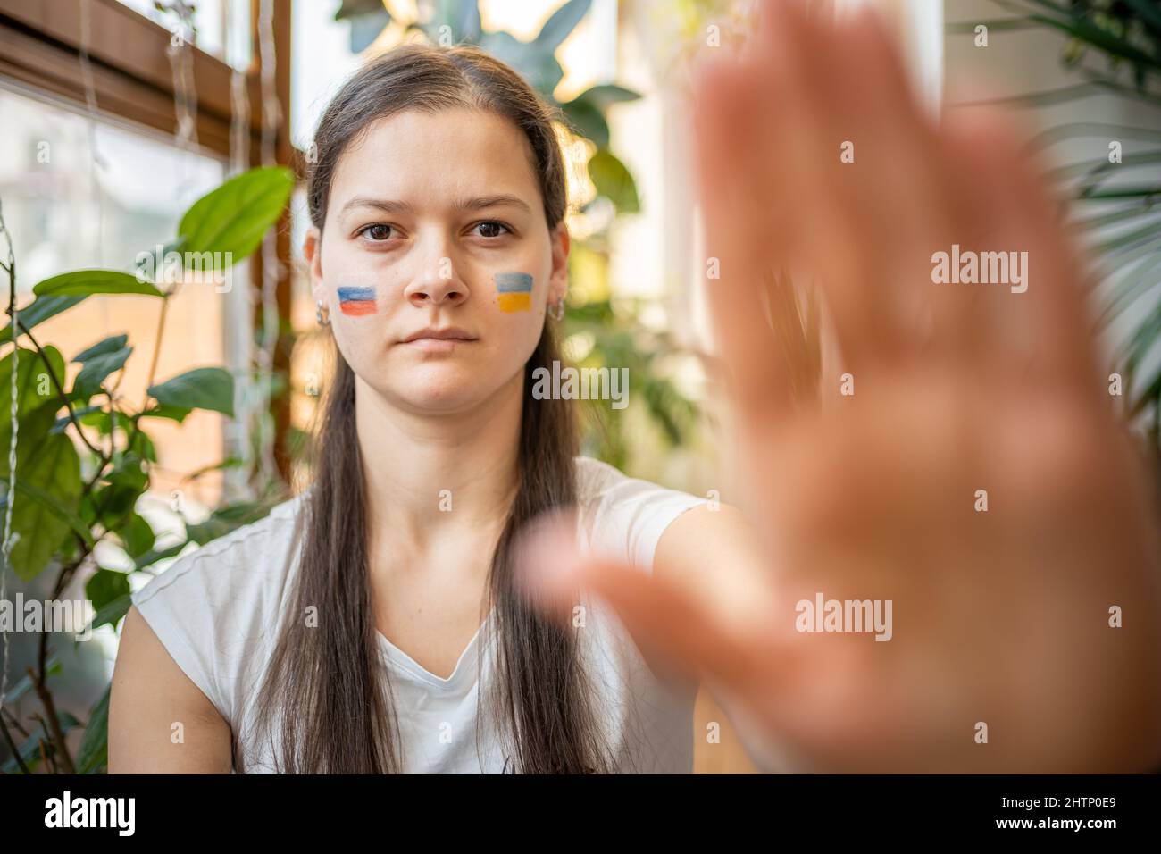A young Russian-Ukrainian girl with the flag of Ukraine and Russia on ...
