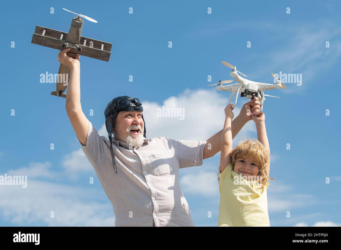 Child boy and grandfather playing with toy plane and quadcopter drone ...