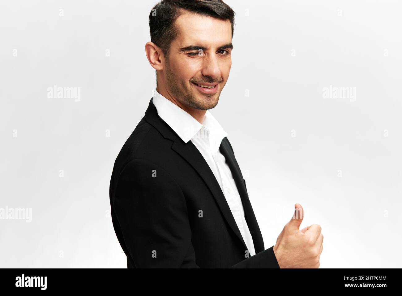 man in black business suit showing thumb up winking successful job ...