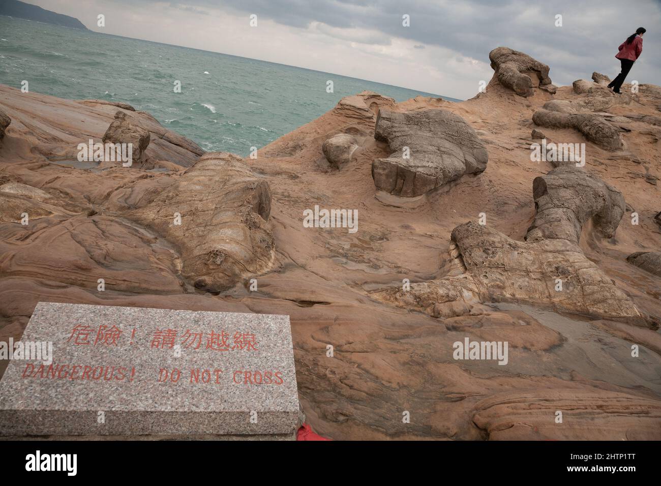 "Ginger Rocks" at A woman ignores a warning sign at Yehliu Geopark, New ...