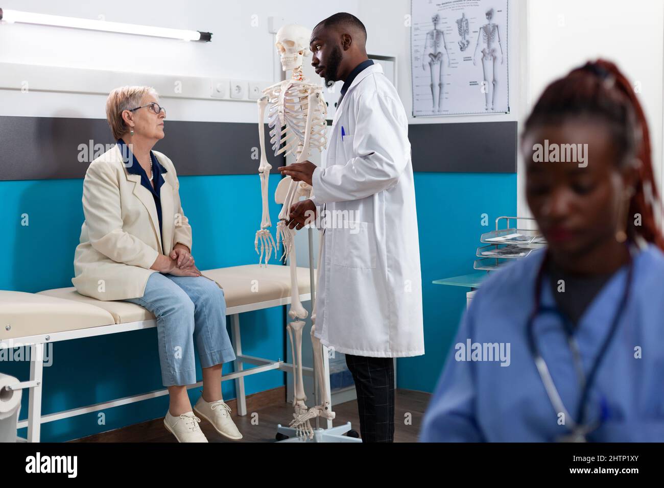Chiropractor doctor holding anatomy human skeleton arm explaining bones ...