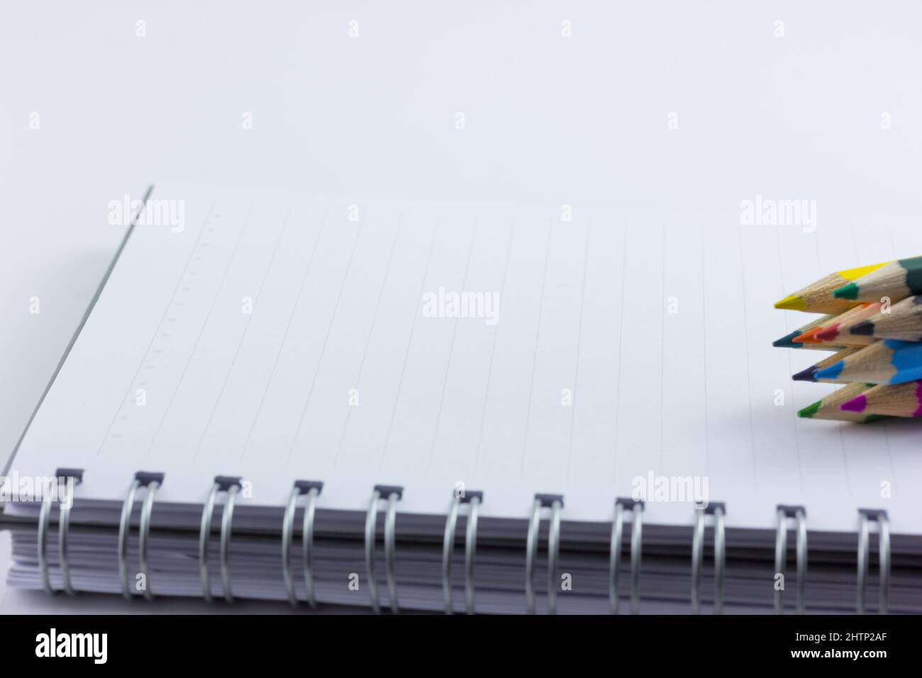 Notebook with colorful pencil on white background Stock Photo - Alamy