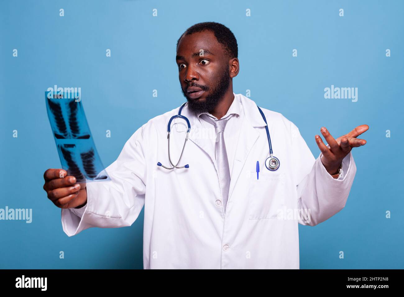 Shocked medic in white lab coat with stethoscope looking surprised at ...