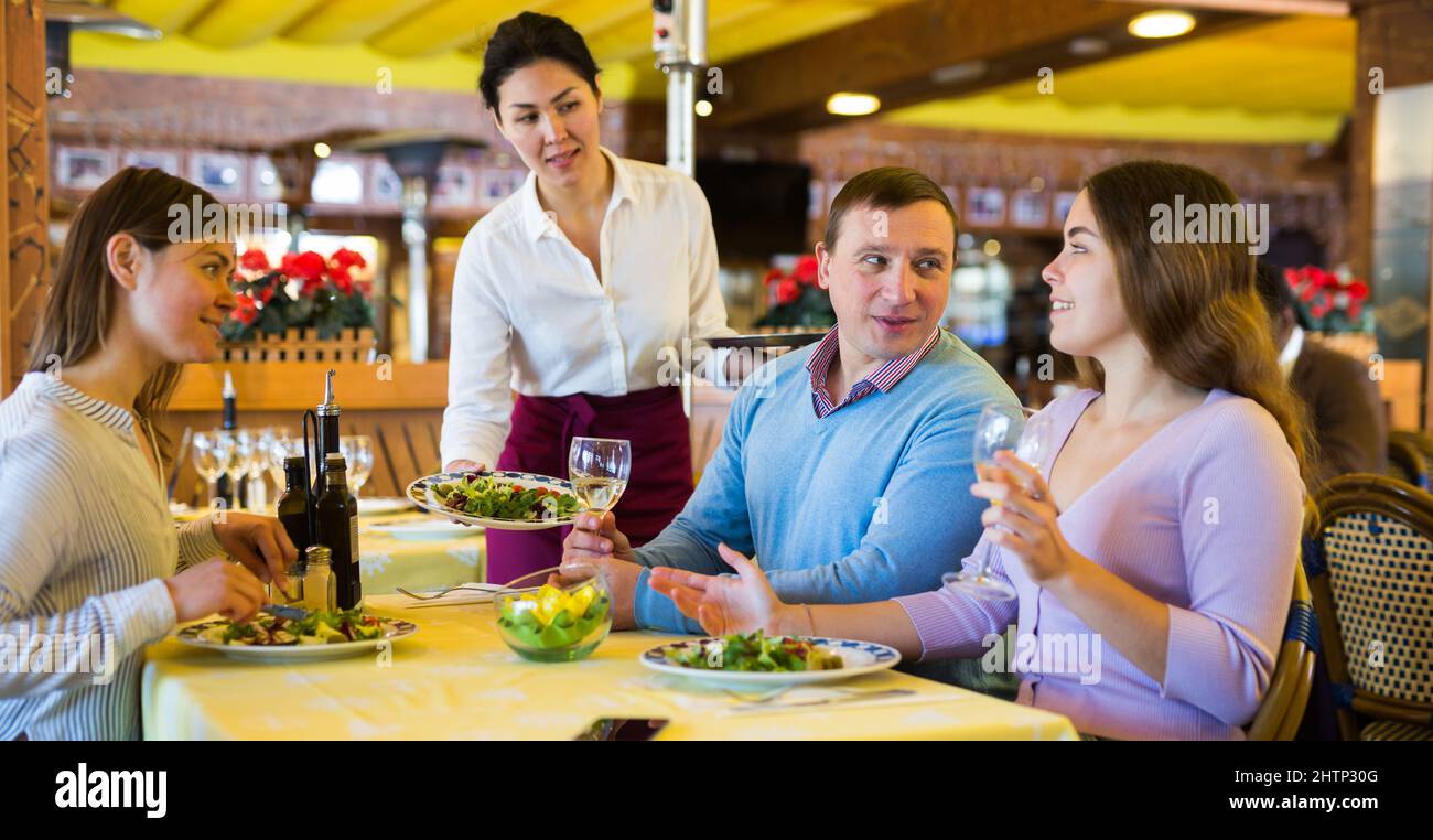 Happy friends meeting in restaurant during dinner Stock Photo - Alamy
