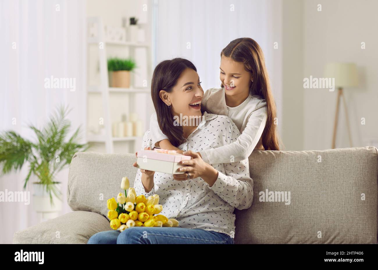Caring daughter greeting mom make surprise Stock Photo - Alamy