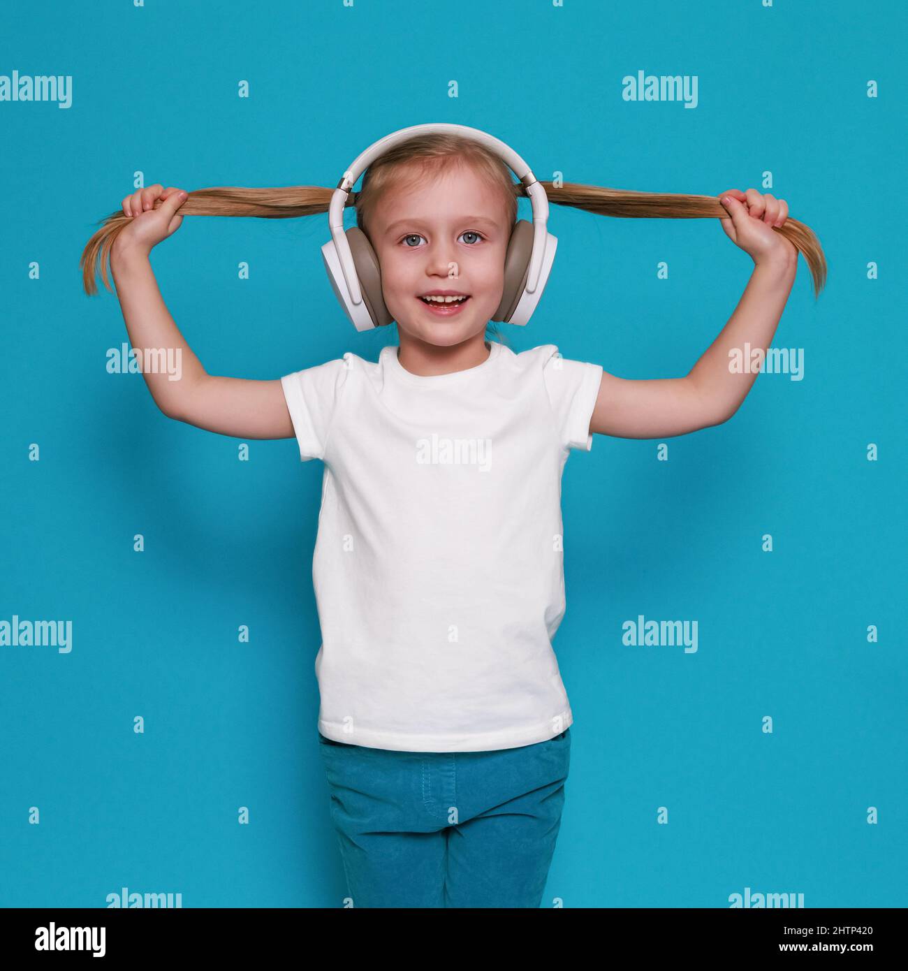 Mocap, little girl in white t-shirt and headphones is dancing on blue ...