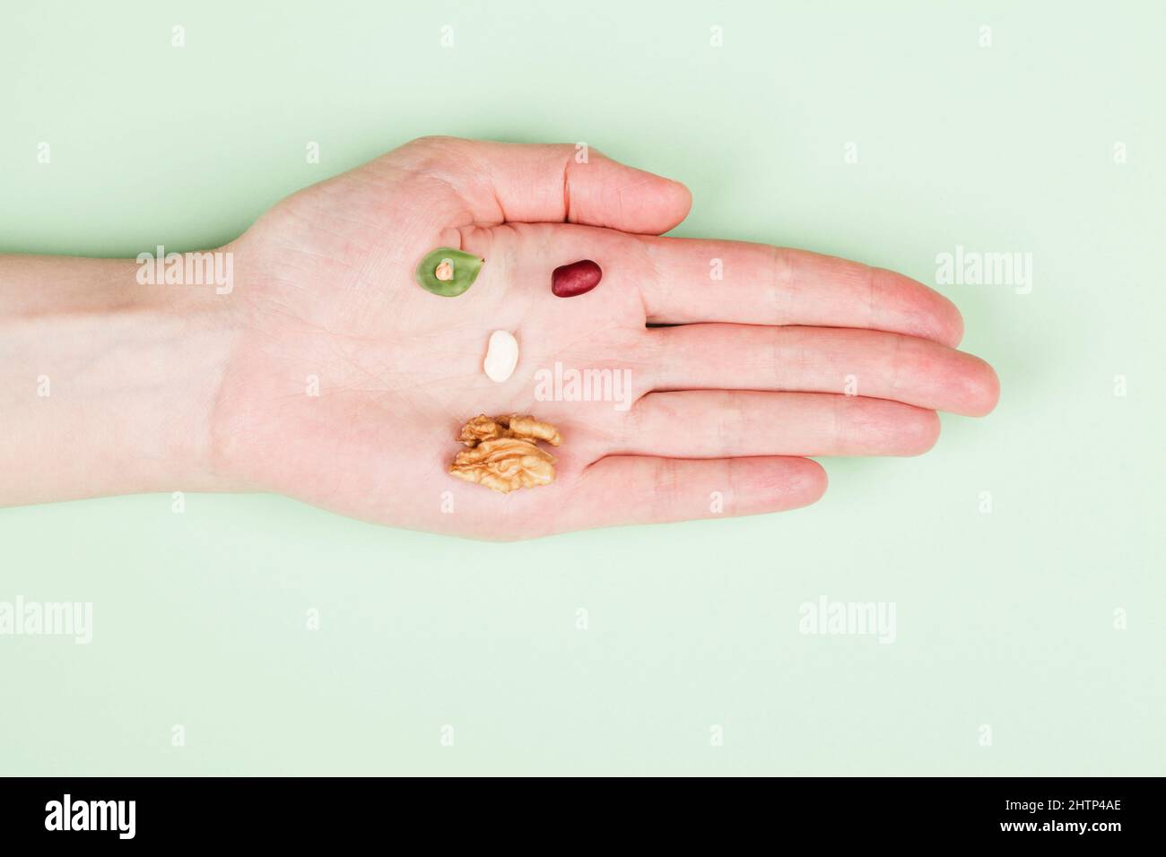 healthy eating . Top view of beans and nut in form of face on hand on ...