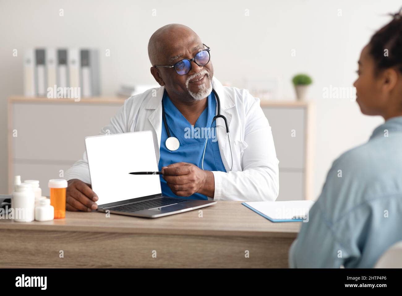 Experienced black doctor explaining treatment plan to female patient ...