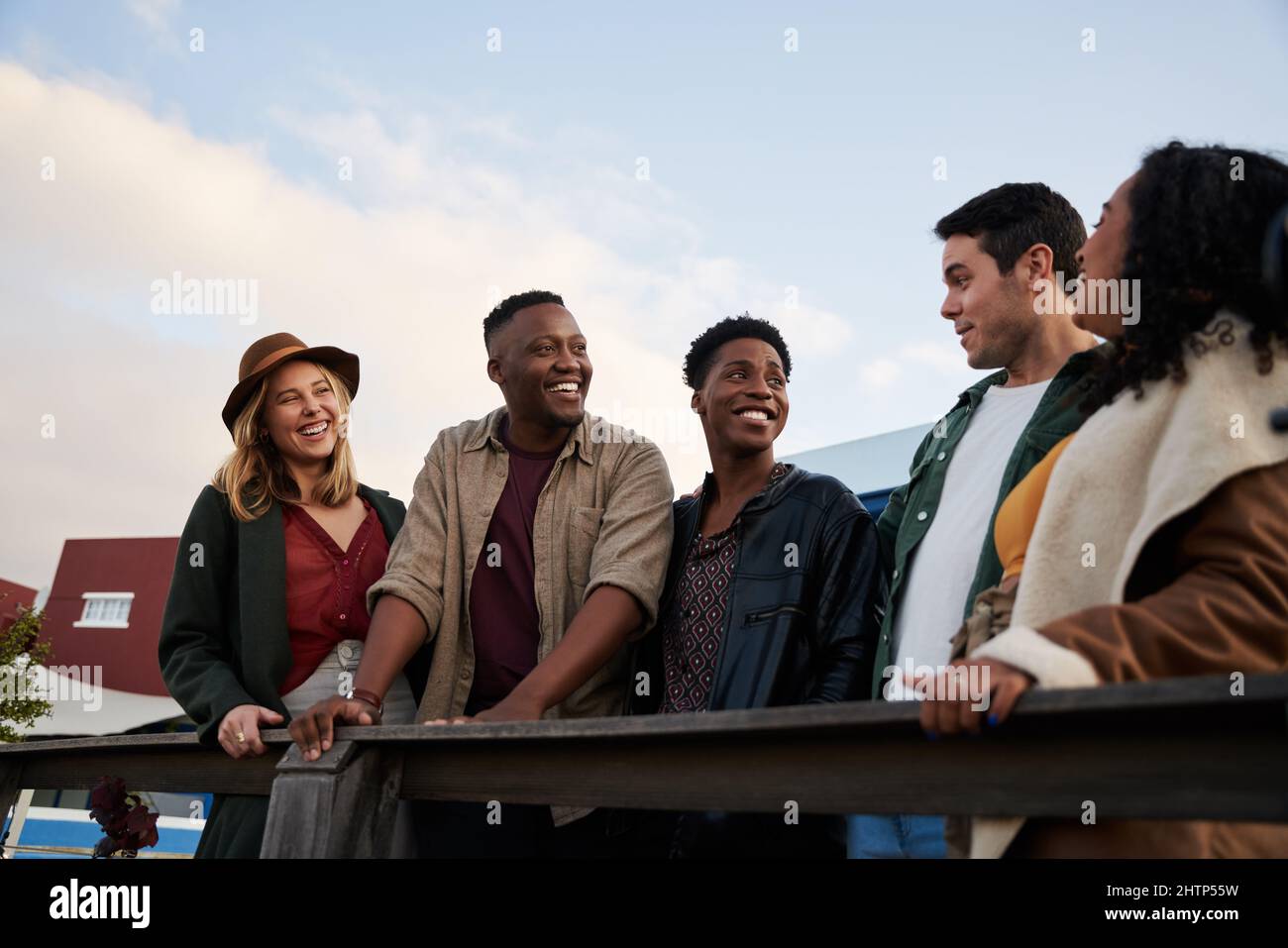 Trendy, diverse group of friends standing and chatting together on ...