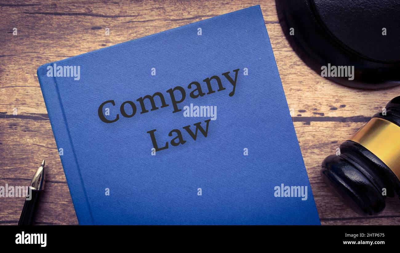Company law book and gavel on a brown wooden table Stock Photo - Alamy