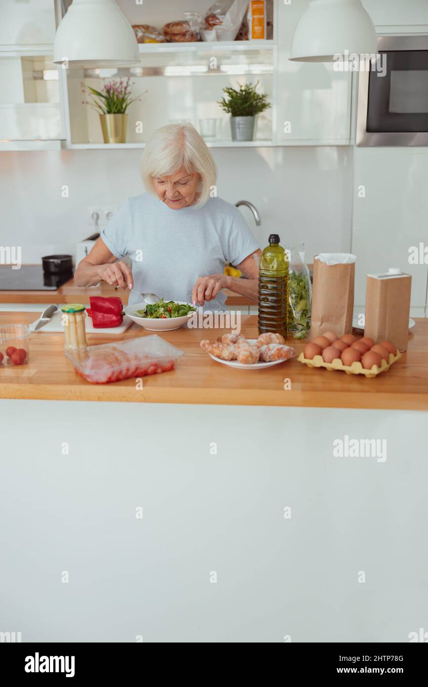 Elderly woman cooking in kitchen at home Stock Photo - Alamy