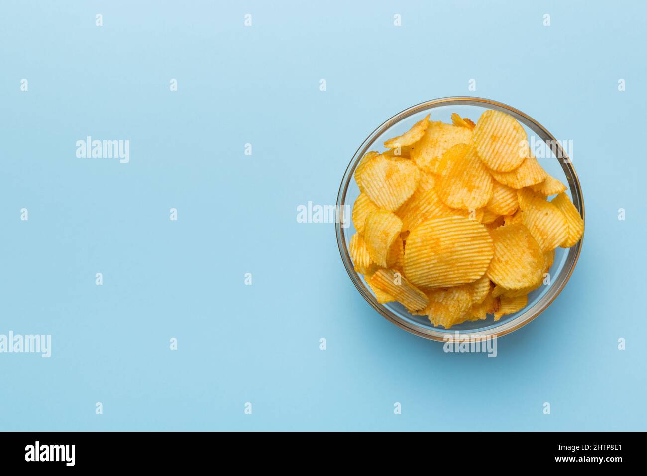 Potato chips on bowl isolated on colored background. Delicious crispy ...