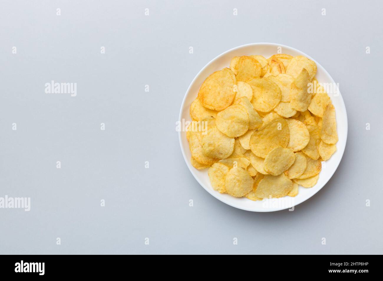 Potato chips on bowl isolated on colored background. Delicious crispy ...