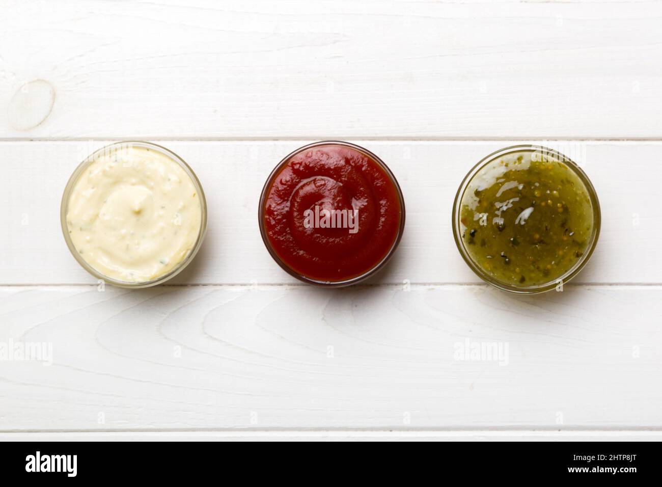 Different types of sauces in bowls on a colored Board . Top view ...
