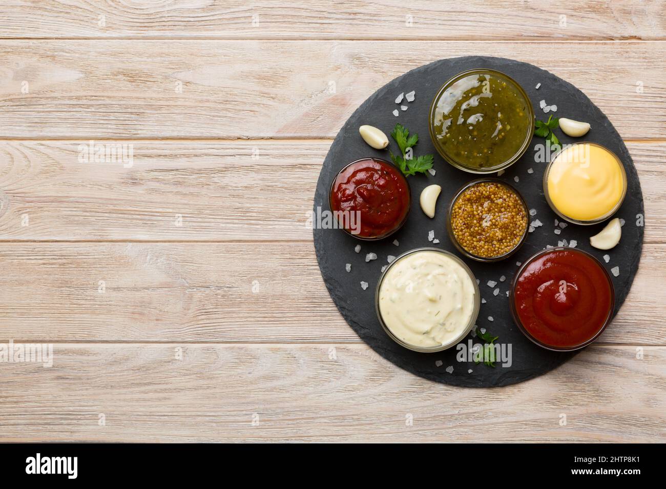 Many different sauces and herbs on table, flat lay top view. sauces on ...