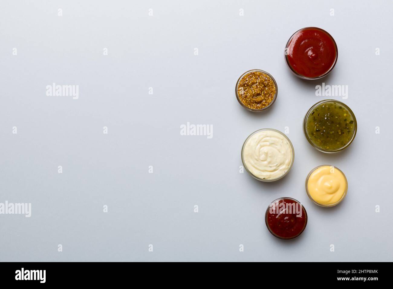 Different types of sauces in bowls on a colored Board . Top view ...