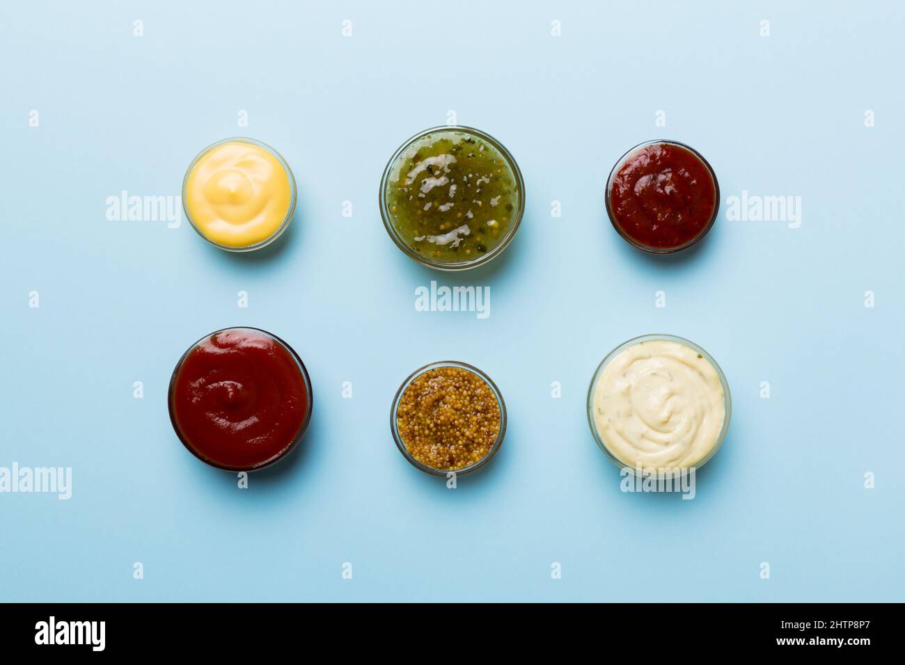 Different types of sauces in bowls on a colored Board . Top view ...